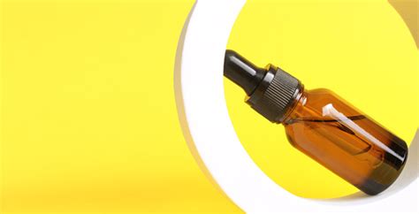 노란색 배경에 기하학적 둥근 형태의 호박색 유리 드롭퍼 병 화장품 용기 모형 브랜딩 및 패키징 프레젠테이션을 위한 배경 내츄럴 스킨케어 뷰티 제품 컨셉 0명에 대한 스톡