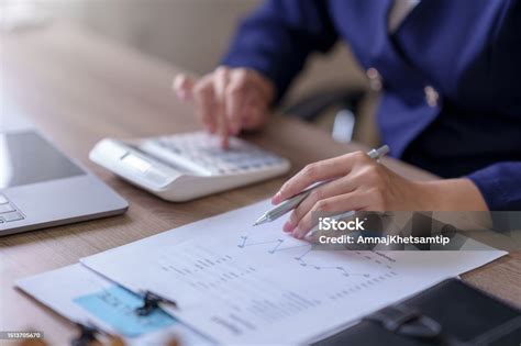 회사 계정 재정 소득 대차 대조표 및 예산을 감사하기 위해 계산기를 사용하여 계산하고 메모하는 비즈니스 여성의 손을