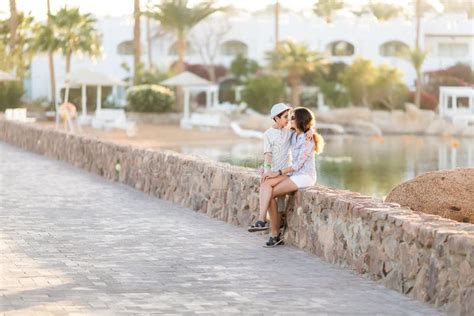 Мальчик в футболке и шортах и блузка женщине в белых на ландшафте лета Мать и сын Семейные