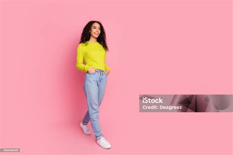 곱슬 갈색 머리를 가진 청소년 소녀가 캐주얼 한 옷을 입고 포즈를 취하고 분홍색 배경에 고립 된 빈 공간으로 걸어가는 전신 길이 사진 18 19세에 대한 스톡 사진 및 기타