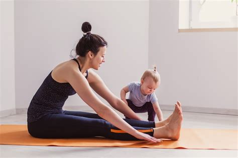 La Madre Practica Yoga En Casa Con Su Hijo Foto Premium