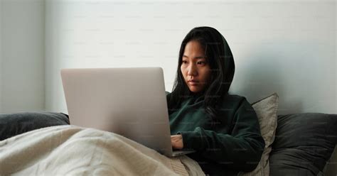 침대에 앉아 노트북 컴퓨터를 사용하는 여성 사진 Unsplash의 불경기 이미지