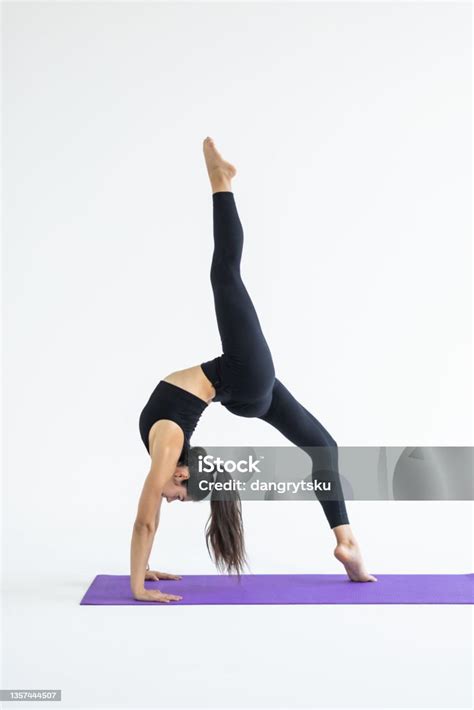 젊은 매력적인 여자 연습 요가 다리 운동에 서 한 다리 바퀴 포즈 스포츠웨어를 입고 운동 흰색 바지 실내 전체 길이 흰색 배경에 고립 건강한 생활방식에 대한 스톡 사진 및