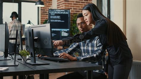 Two Programers Holding Laptop With Coding Interface Walking Towards
