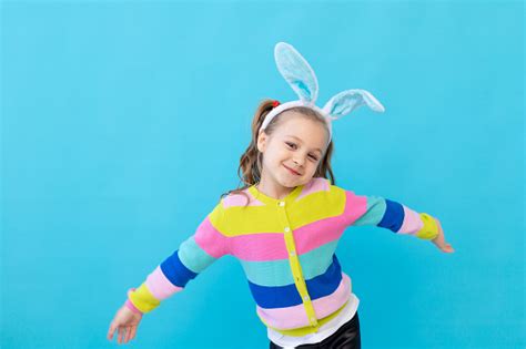 줄무늬 재킷에 토끼 귀를 가진 어린 소녀의 초상화미소와 탐닉 부활절 휴일의 개념 파란색 배경 사진 스튜디오 텍스트 장소 부활제에 대한 스톡 사진 및 기타 이미지 Istock