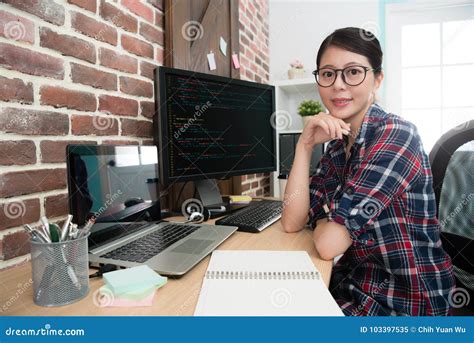 a female programmer typing source codes and using mobile phone in a