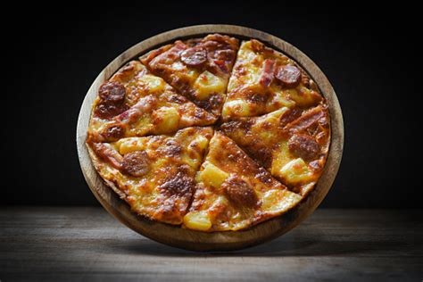 모짜렐라 훈제 돼지 고기 소시지 파인애플 햄 토핑 소스 레스토랑 또는 어둠 에 피자 를 곁들인 나무 접시 맛있는 패스트 푸드 이탈리아 전통 피자 치즈에 피자 고기에 대한