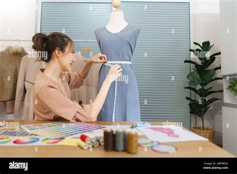 Fashion Design Concept Asian Female Designer Use Tape Measure To Measuring Dress On Mannequins