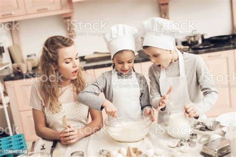 부엌에서 어머니와 함께 아이 자매는 반죽을 교반하고 동생은 우유를 들고있다 10 11세에 대한 스톡 사진 및 기타 이미지 10 11세 25 29세 6 7 살 Istock