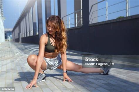 세련 된 실버에 긴 머리 스포티 한 여자 색 반바지와 어두운 녹색 T셔츠는 도시 배경에 운동 사진 중 일출에서에서 만든 아름 다운 여름 아침 20 29세에 대한 스톡 사진