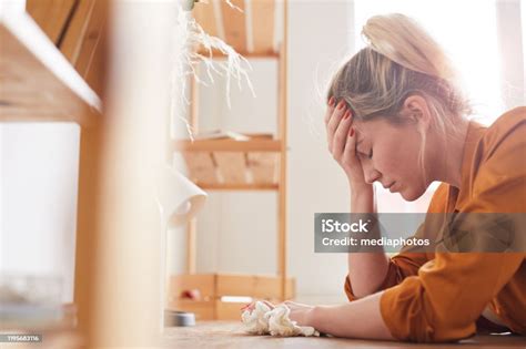 구겨진 냅킨과 함께 테이블에 앉아 머리를 손에 들고 슬퍼하는 눈을 감은 절망적 인 젊은 여성 가정의 방에 대한 스톡 사진 및 기타 이미지 Istock