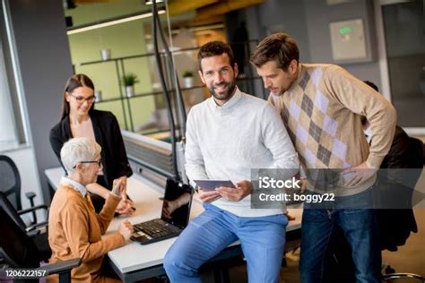 백그라운드에서 앉아있는 동료와 함께 사무실에 서있는 동안 일하고 의사 소통하는 비즈니스 사람들 경영자에 대한 스톡 사진 및 기타 이미지 Istock