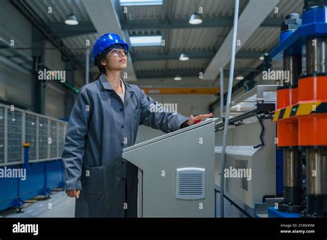 Indian Woman Engineer With A Blue Helmet And Safety Goggles Operating