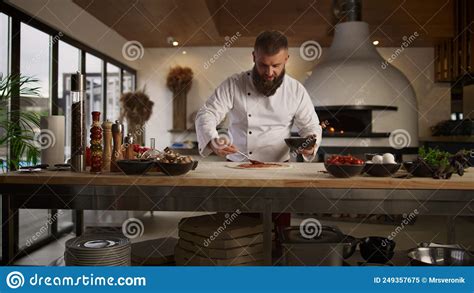 Man Cooking Italian Pizza In Restaurant Chef Spreading Tomato Sauce In