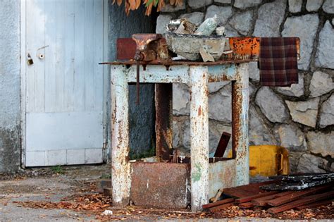 석조 벽과 잠긴 문 배경에 건축 자재와 쓰레기로 둘러싸인 오래 된 금속 테이블에 장착 된 녹슨 워크 벤치 바이스 0명에 대한 스톡 사진 및 기타 이미지 Istock