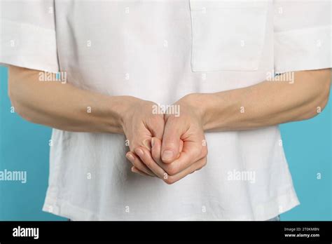 Woman Cracking Her Knuckles On Turquoise Background Closeup Bad Habit