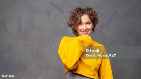 밝은 노란색 스웨터를 입고 짧은 곱슬 머리를 가진 행복한 쾌활한 젊은 여성 9월에 대한 스톡 사진 및 기타 이미지 9월 가을 갈색 머리 Istock