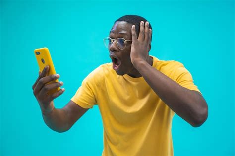 Shocked African American Guy Looking At Smartphone Screen Amazed Black