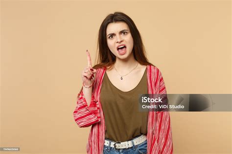 캐주얼 맹세에서 자극 젊은 여자의 초상화 스튜디오에서 파스텔 베이 지 배경에 고립 된 포인팅 인덱스 손가락 사람들은 진심으로