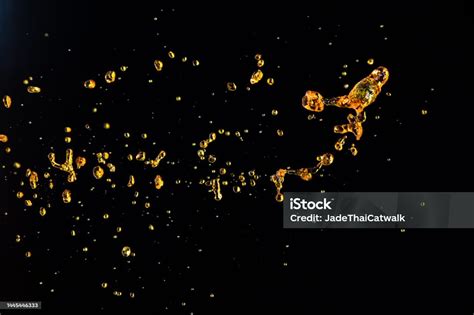 오렌지 레몬 주스 또는 오일 윤활유 스플래시 액체 골드 노란색 음료 방울 선 형태의 과일 음료 물 요소 신선한 튀고 흐르는 제트기 검은 배경 격리 된 동결 동작 가솔린에