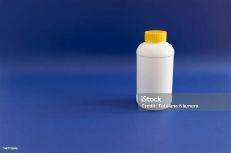 흰색 플라스틱 병 보라색 파란색 배경에 파이프 과립 청소기가 있는 노란색 모자 싱크대의 막힘 제거 특수 화학 물질로 샤워 부엌 Bathroomcopyspace에 있는 막힘