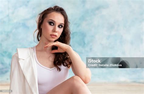 하얀 체조 레오타드를 입은 프로 발레리나가 파란 벽이 있는 방에서 춤을 추고 있다 20 24세에 대한 스톡 사진 및 기타 이미지