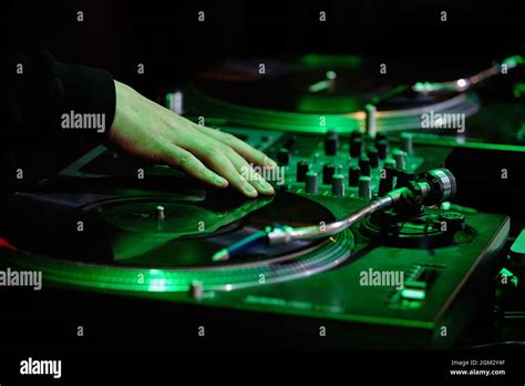 Hand Of Hip Hop Dj Scratching Vinyl Record On Turntables In Green Neon