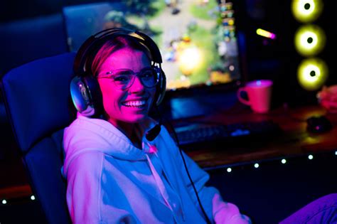 귀여운 매력적인 금발 소녀 앉아 안락 의자 미소 놀이 게이머 컴퓨터 보라색 파란색 네온 불빛 실내 늦은 밤 사진 25 29세에 대한 스톡 사진 및 기타 이미지 Istock