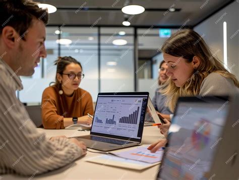 Team Members Analyzing Customer Data Graphs And Charts In Modern Office
