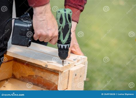 Man Is Screwing Into Wooden Box With Cordless Screwdriver Product Repair With Professional Tool