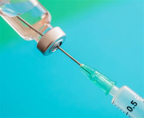 Premium Photo Vaccine Vial Dose And Syringe Against Pale Blue Background