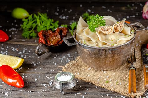 빈티지 소박한 그릇 접시 포크 나이프 숟가락 소금 향신료 신선한 허브 스탠드 와 거짓말 다른 각도 나무 절단 부엌 테이블에 어두운 빛에 빨간색과 흰색 생선 고기로 만든 만두