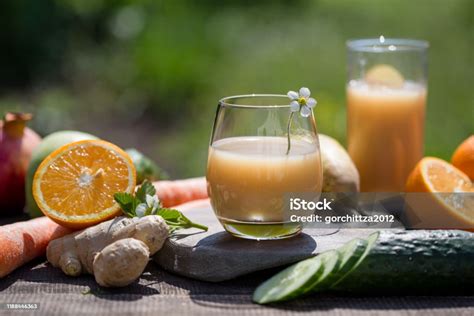 천연 테이블에 멀티 과일 주스와 신선한 과일 믹서기와 녹색 정원 배경에 나무 소박한 테이블에 마시는 멀티 과일 주스 또는 스무디 다과의 신선한 이국적인 과일과 유리 건강한