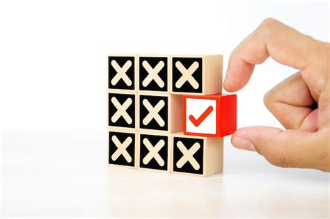 Premium Photo Hand Choose Check Mark On Cube Wooden Toy Block With Cross Symbol
