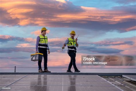 지붕 위를 걷는 엔지니어는 보류 장비 상자 및 무선 통신에 의해 태양 전지 패널을 검사하고 점검하며 태양 전지는 스마트 그리드