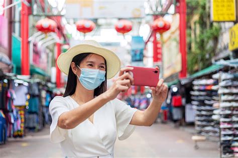 차이나타운에서 얼굴 마스크와 모자를 쓰고 사진을 찍는 행복한 여성 여행자 개성 개념에 대한 스톡 사진 및 기타 이미지 개성