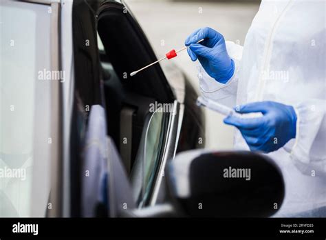 Medical Workers Hands In Gloves Holding Pcr Testing Kit In Mobile Testing Drive Thru Center