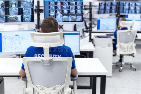 Security Control Room With Surveillance Monitors And Guard Officer