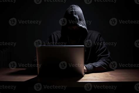 Hacker Wearing Black Hoodie Using Laptop Computer While Working On Dark