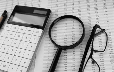 calculator magnifying glass pen eye glasses on financial statement