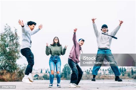 강변 근처를 뛰어다니며 기쁨과 동지애를 발산하고 도시 풍경에서 젊음의 활기로 학업 성공을 축하하는 활기찬 대학 친구들 18 19세에 대한 스톡 사진 및 기타 이미지 Istock