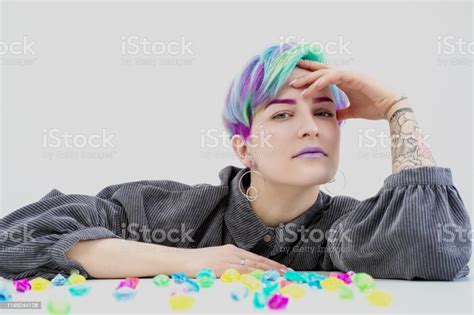 짧은 요정 밥 헤어 스타일과 염색 머리와 젊은 여자 입에 손에 보석과 보석을 보유 하 고 있습니다 털에 대한 스톡 사진 및 기타