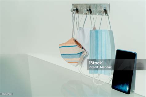 코로나 바이러스 동안 휴대 전화에 추적 응용 프로그램에 문의 휴대 전화 기술 장치 개념으로 집에 매달려 있는 얼굴 마스크 외과