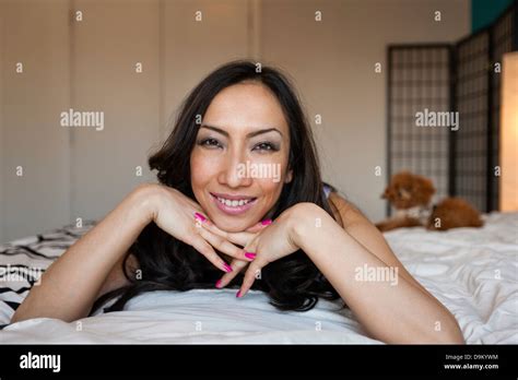 Mid Adult Woman Lying On Bed Portrait Stock Photo Alamy