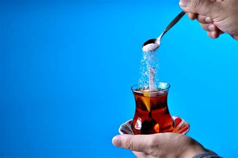 레몬 한 조각을 넣은 양조 홍차 한 잔과 숟가락으로 과립 설탕을 차에 붓는 남자의 손 건강에 좋지 않은 음식에 대한 스톡 사진 및 기타 이미지 건강에 좋지 않은 음식