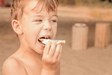 Premium Photo Little Boy Eating Pancakes With Jam On The Beach Toned