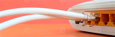 The Internet Cable Plugs Are Connected To The Internet Router Which Lies On A Bright Orange