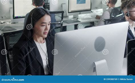 Portrait Of A Technical Customer Support Specialist Talking On A Headset While Working On A