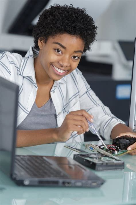 Young Female Electronic Engineer Soldering Computer Motherboard In