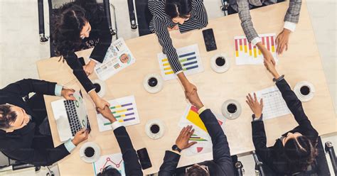 그룹 비즈니스 사람들은 사무실의 회의 테이블에서 악수하고 탑 뷰에서 자신감 있는 샷을 합니다 젊은 사업가와 여성 사업가들은 투자 거래에 대한 동의를 표명합니다 사진